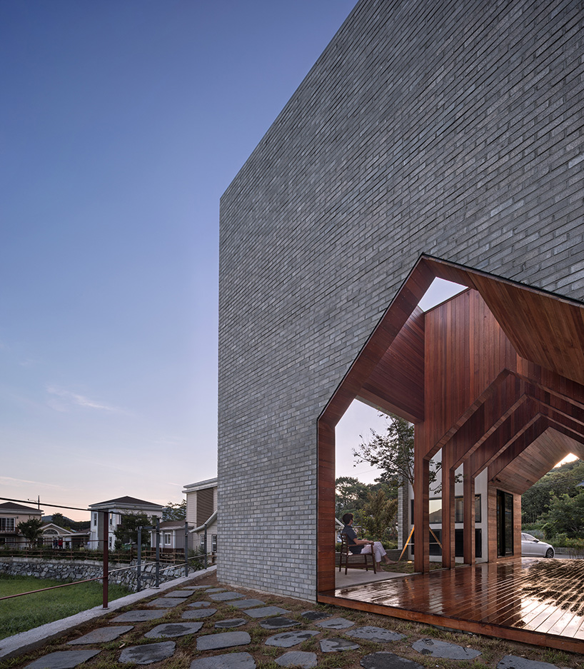 Vernacular Void: Wood Walls Warm Negative Space in Gray Brick Home ...