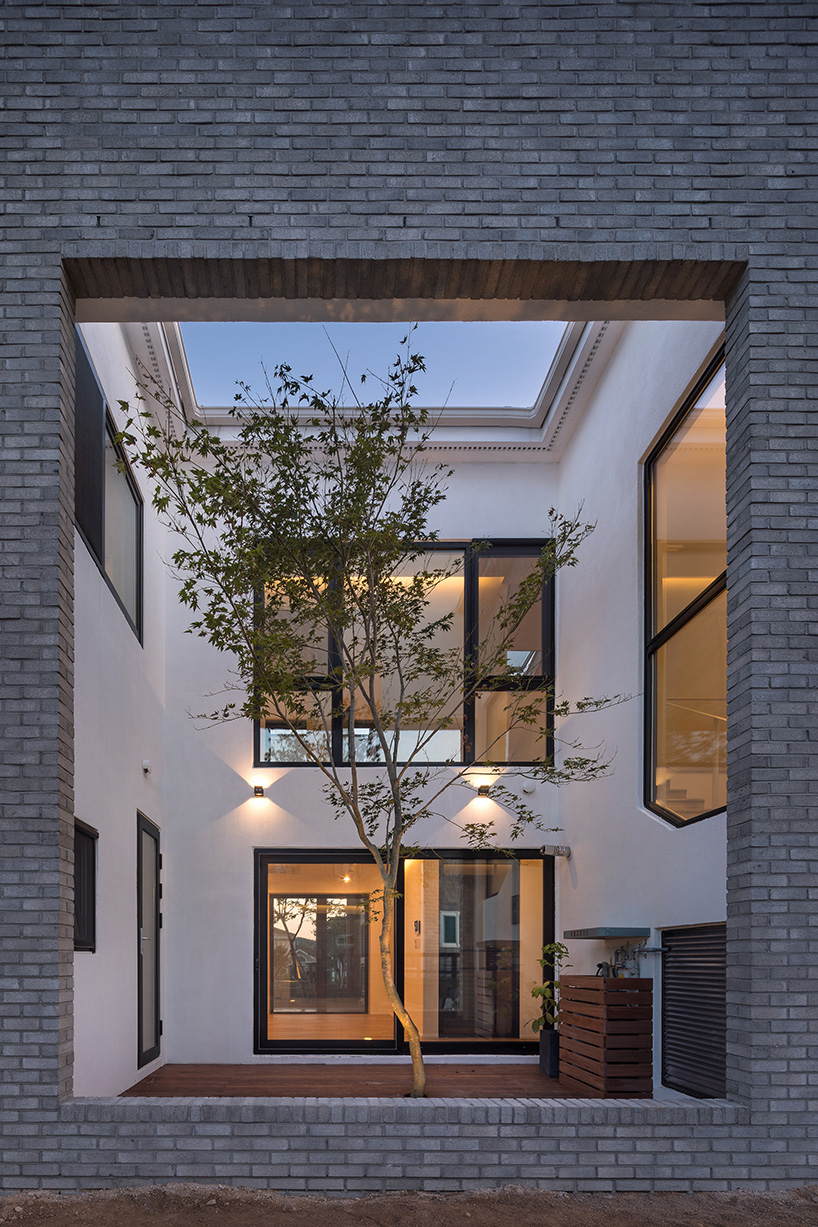 Vernacular Void: Wood Walls Warm Negative Space in Gray Brick Home ...