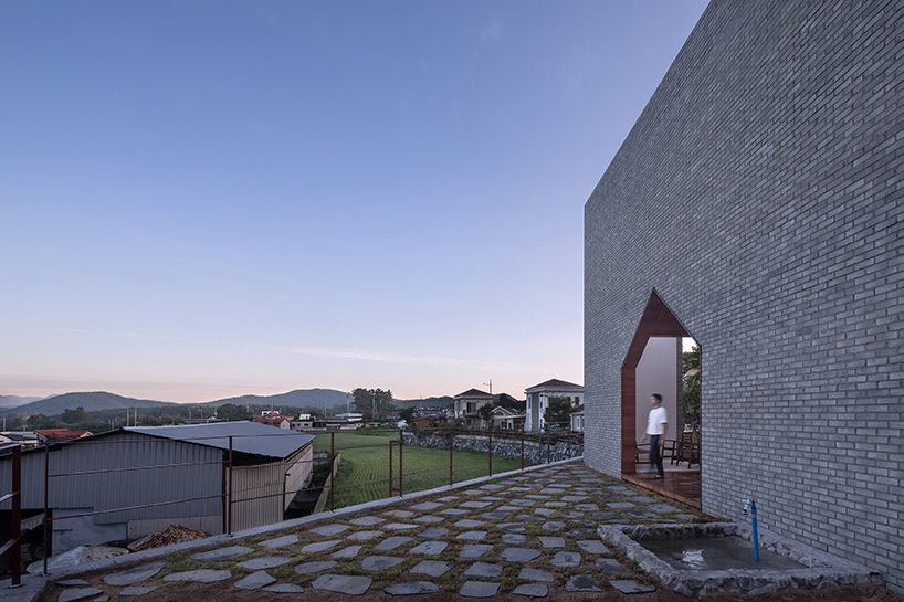 Vernacular Void: Wood Walls Warm Negative Space in Gray Brick Home ...
