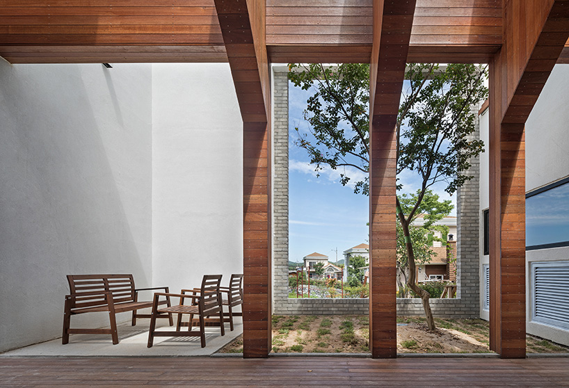 Vernacular Void: Wood Walls Warm Negative Space in Gray Brick Home ...